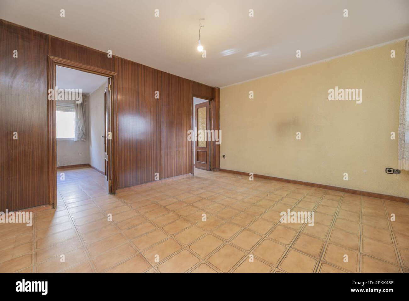 An empty room with poorly painted walls, doors made of sapele wood and ...