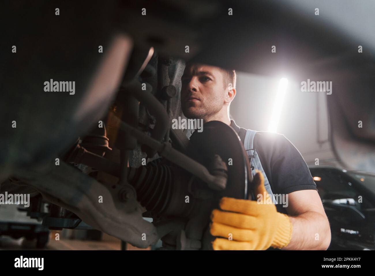 Fixing breaks. Man in uniform is working in the auto service Stock ...