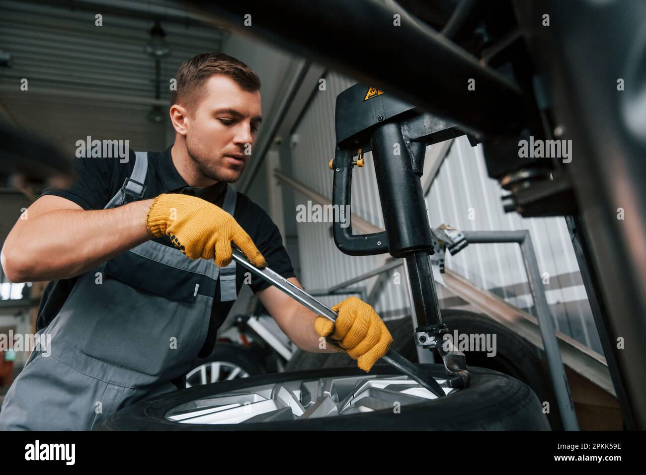 Employee at work. Man in uniform is in the auto service Stock Photo - Alamy