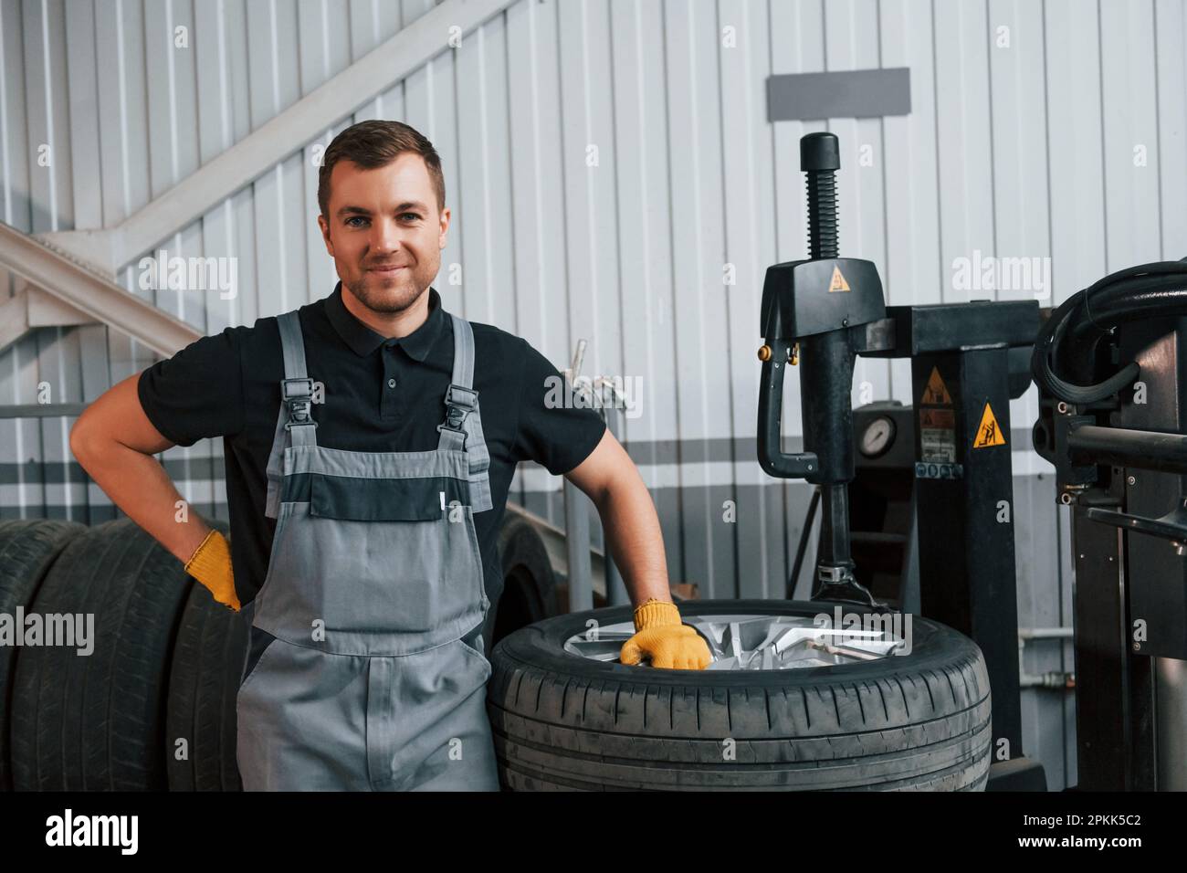 Employee at work. Man in uniform is in the auto service Stock Photo - Alamy