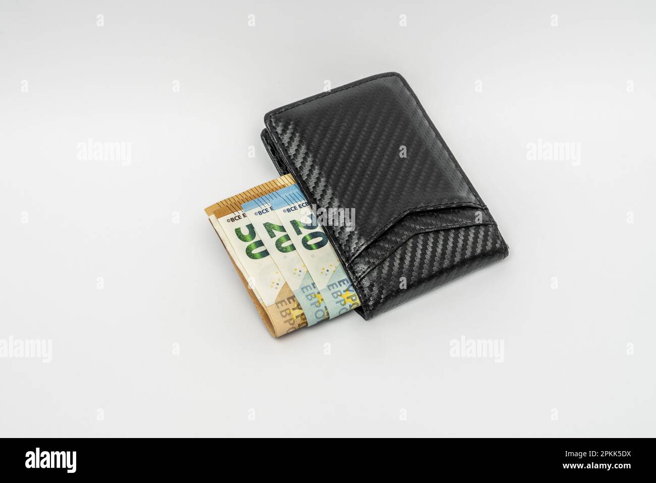 A black carbon fiber braided wallet filled with euro bills Stock Photo ...