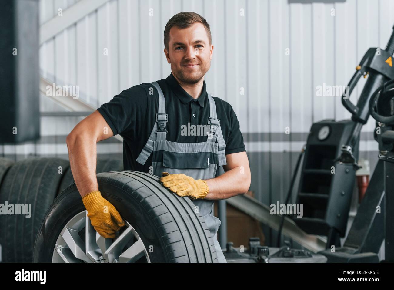 In uniform. Man is working in the auto service Stock Photo - Alamy