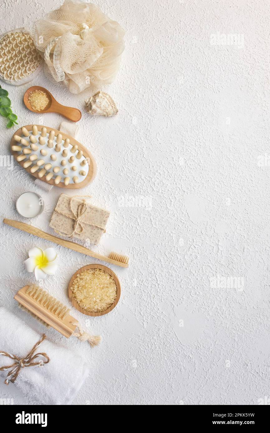 Spa treatment concept. Natural spa products, sea salt, sea stone, massage brush, towel on white ...