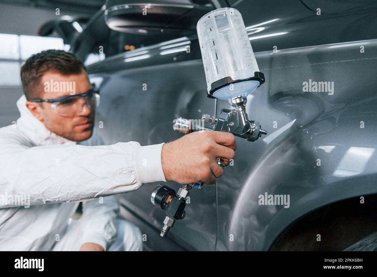 Process of painting the car. Man in uniform is working in the auto ...