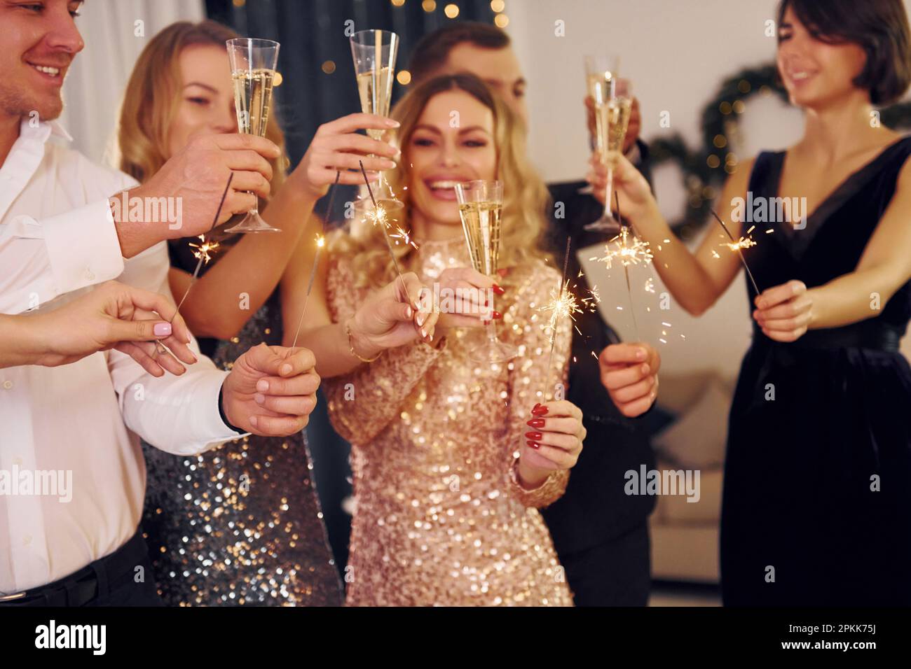 Talking and having fun. Group of people have a new year party indoors ...