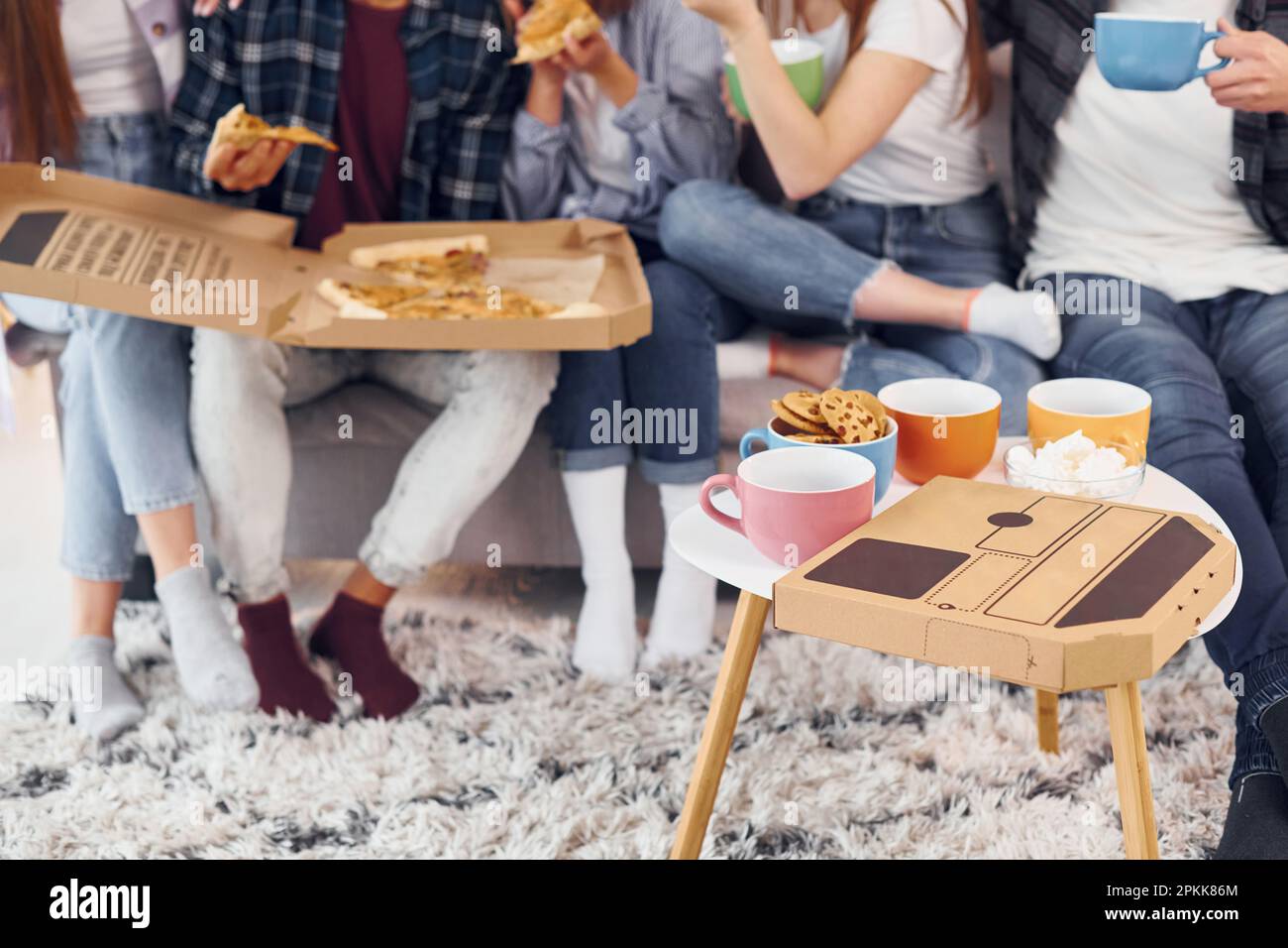 Pizza and cookies. Group of friends have party indoors together Stock ...
