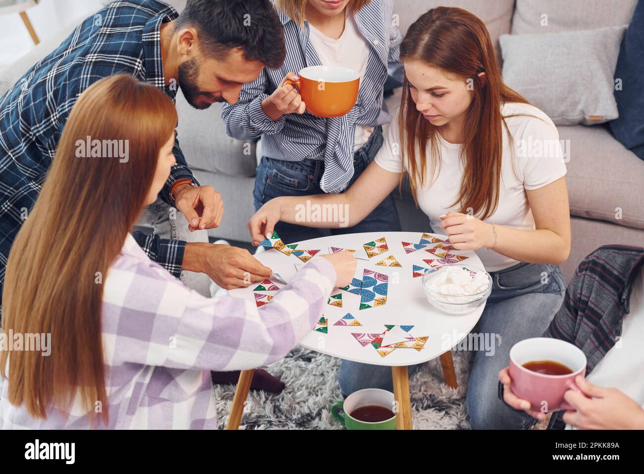 Group friends solving puzzle hi-res stock photography and images - Alamy