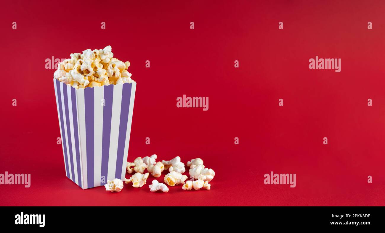 Purple white striped carton bucket with tasty cheese popcorn, isolated ...