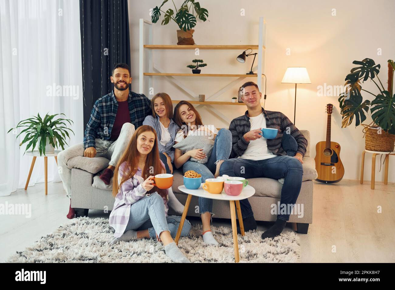 Front view. Group of friends have party indoors together Stock Photo ...