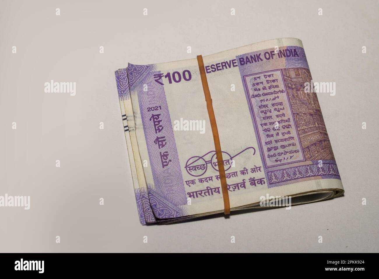The new Indian currency bank notes of 100 rupees bundle on a white ...