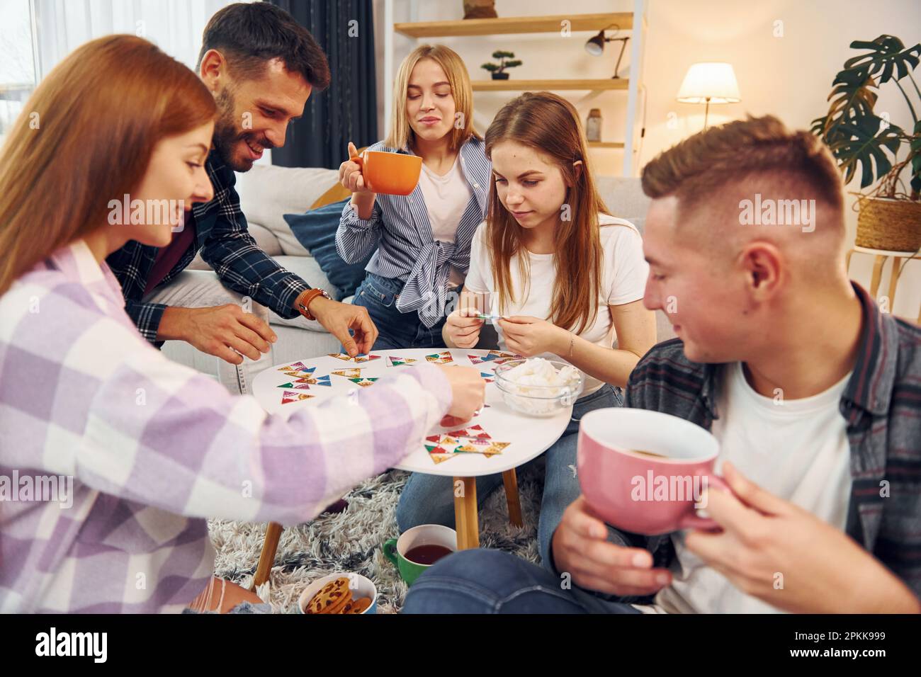 Group friends solving puzzle hi-res stock photography and images - Alamy