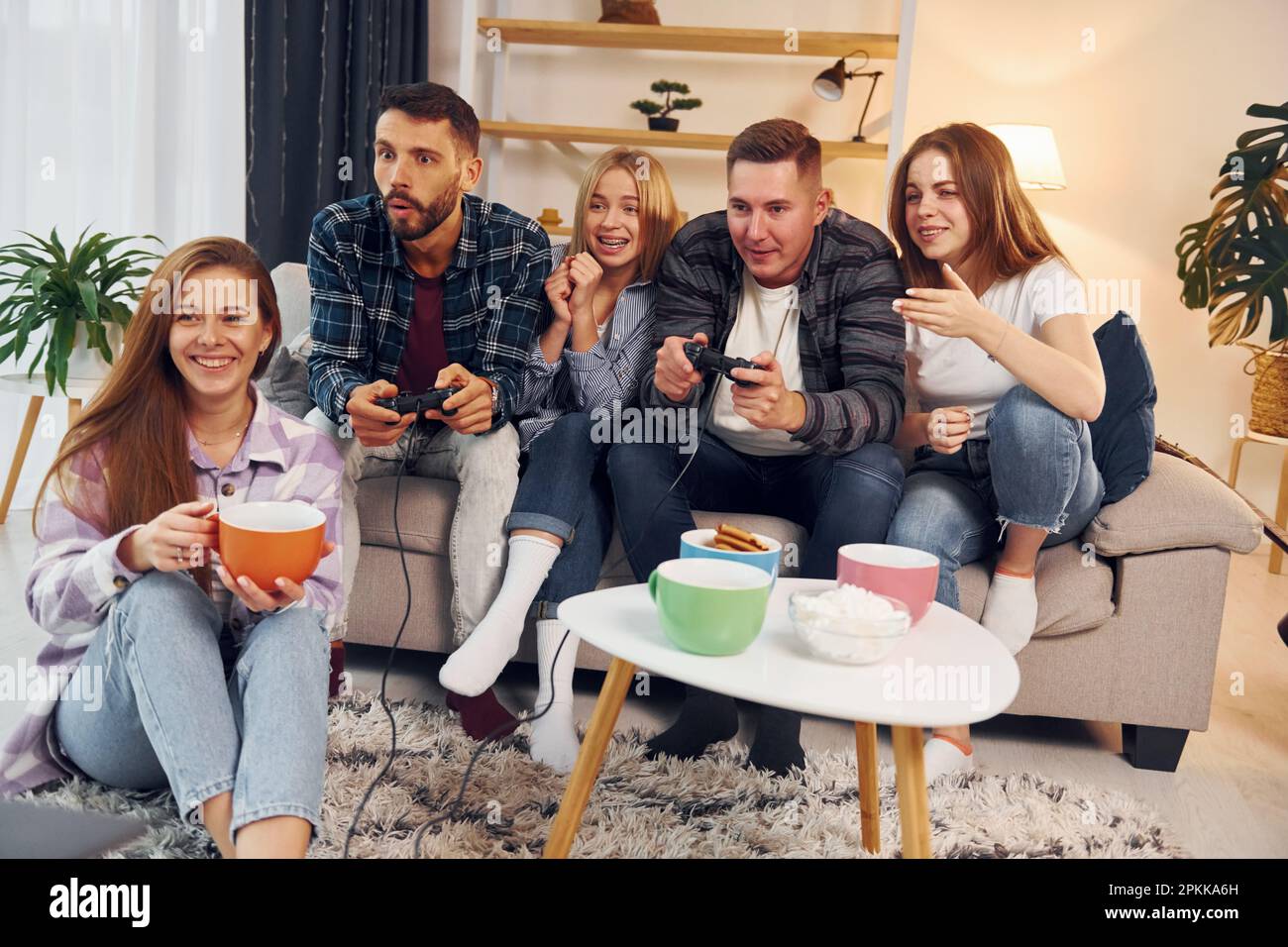 Free time entertainment. Group of friends have party indoors together ...