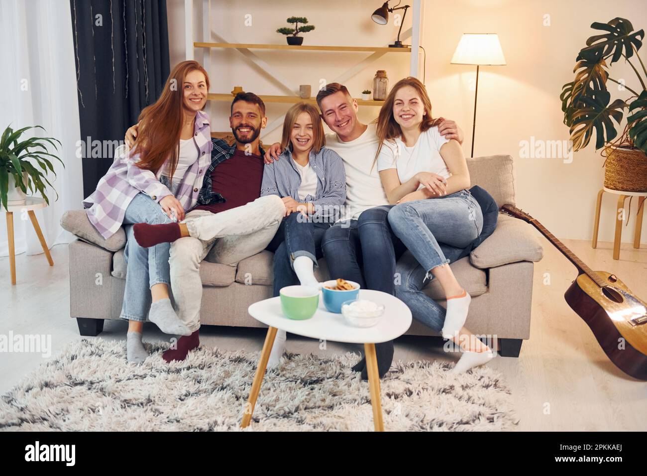 Spending weekend together. Group of friends have party indoors together ...