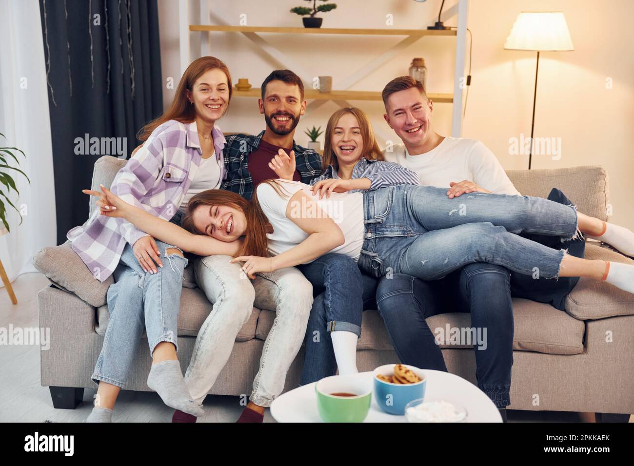 Spending weekend together. Group of friends have party indoors together ...