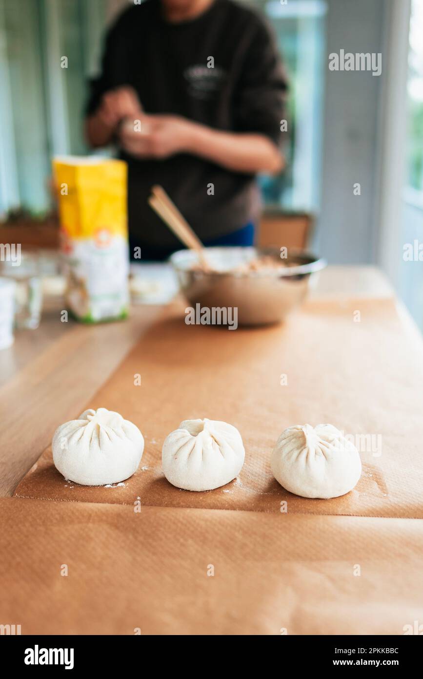 A woman makes bao in the kitchen. Bao, also known as baozi. It's a ...