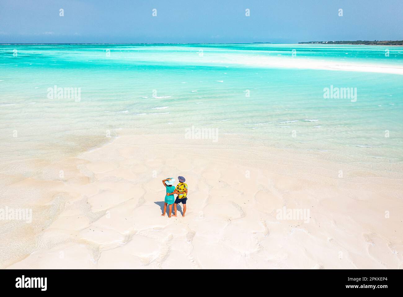Cheerful man and woman embracing on idyllic tropical beach, overhead ...