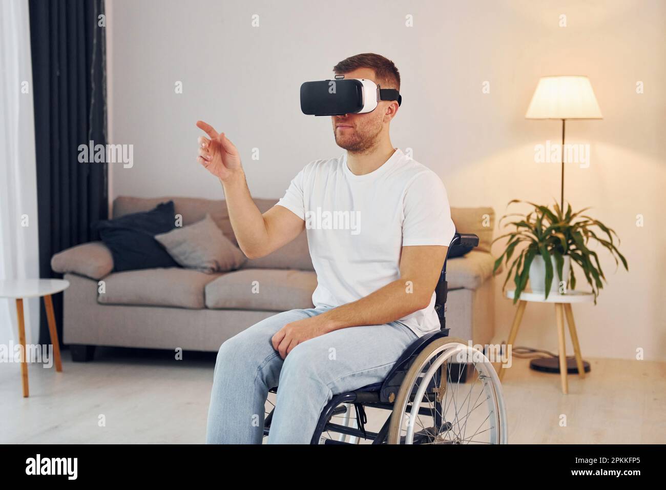 In VR glasses. Disabled man in wheelchair is at home Stock Photo - Alamy