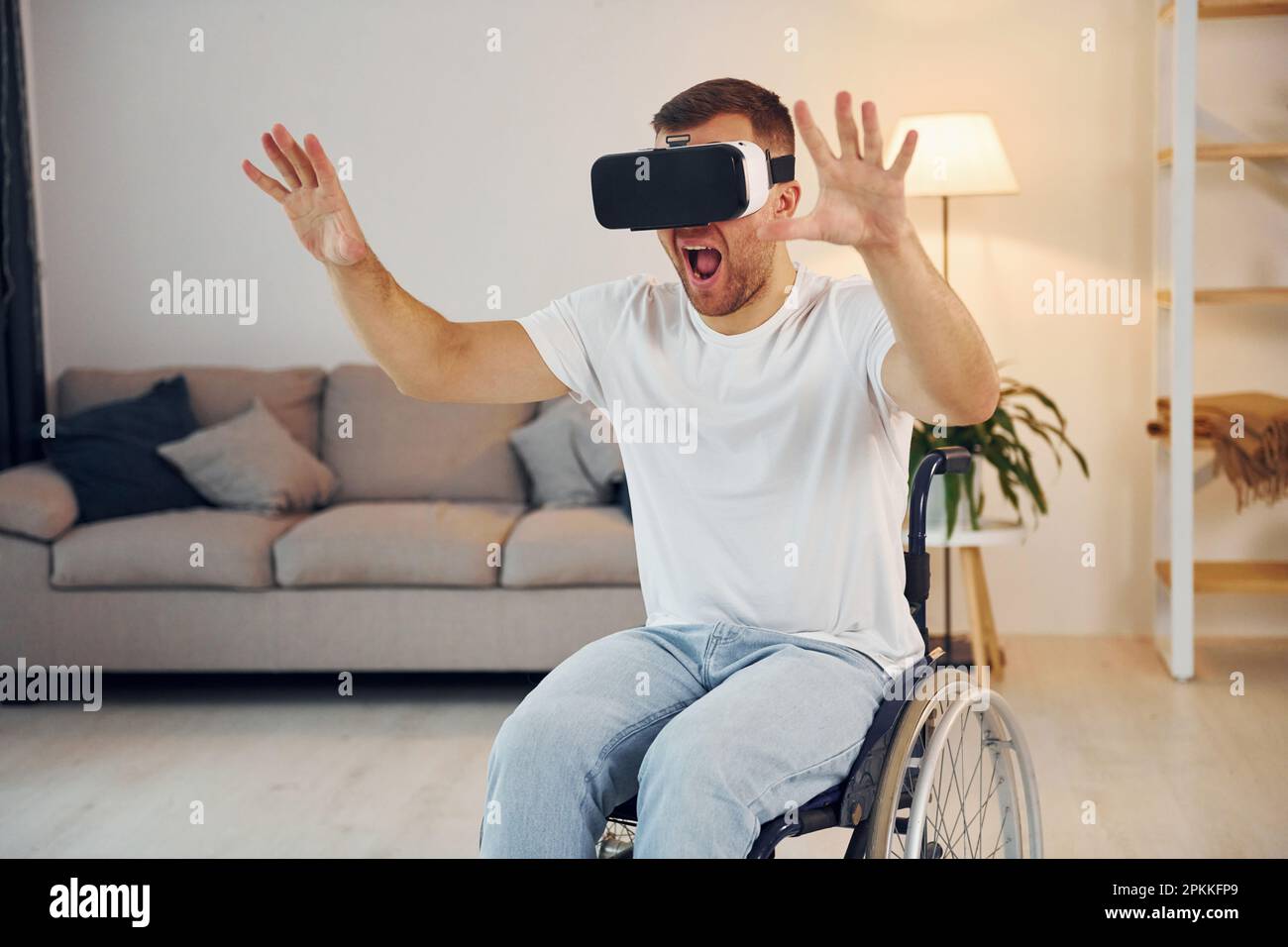 In VR glasses. Disabled man in wheelchair is at home Stock Photo - Alamy