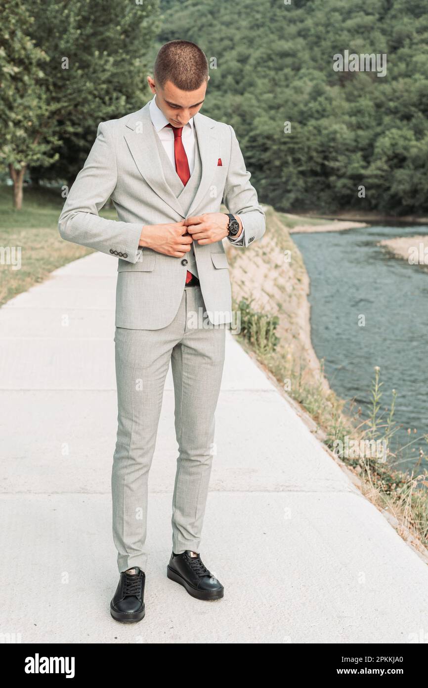 Young teenage boy buttoning his gray suit. Ready for a prom night Stock ...