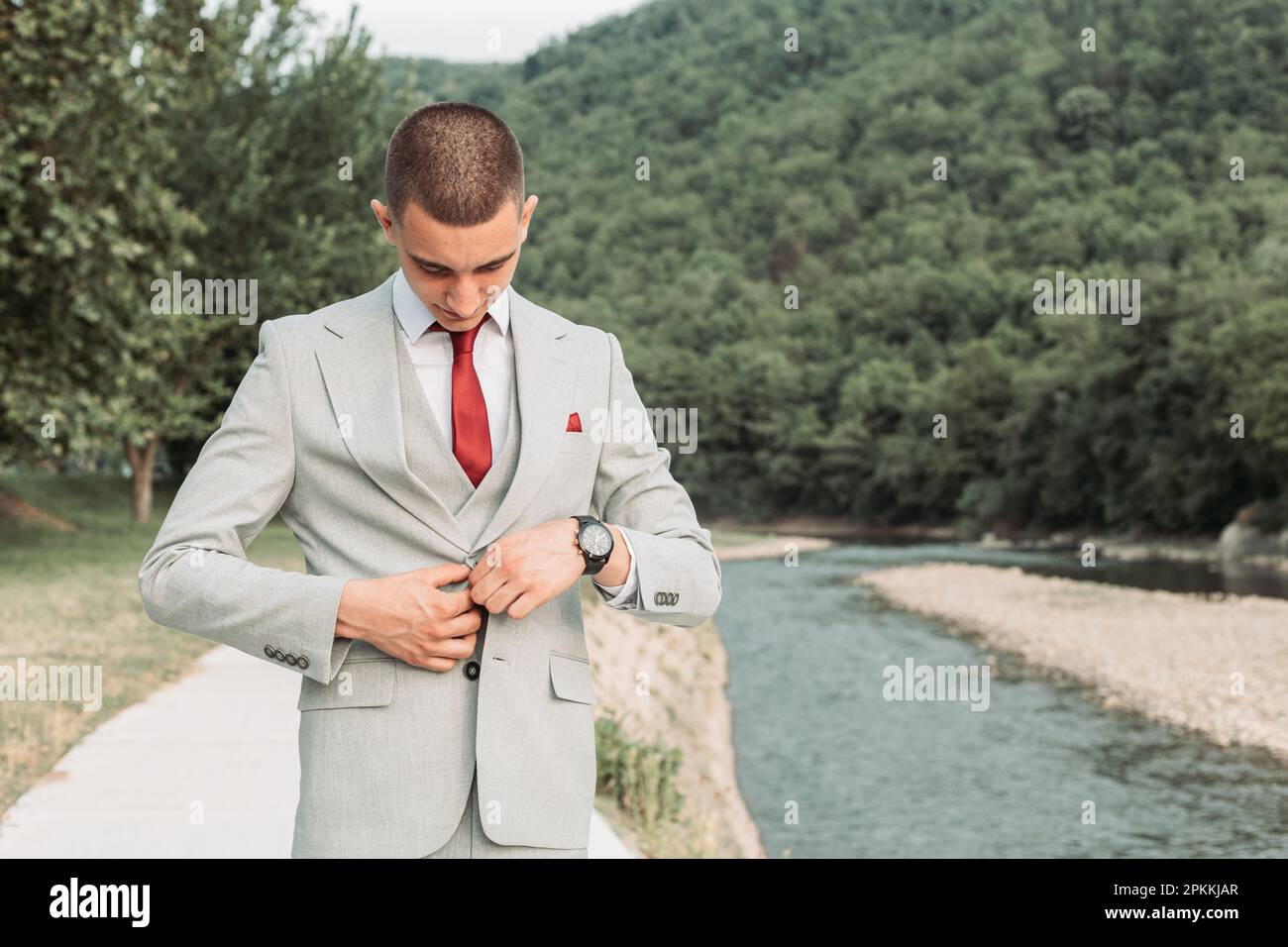 Young teenage boy buttoning his gray suit. Ready for a prom night Stock ...