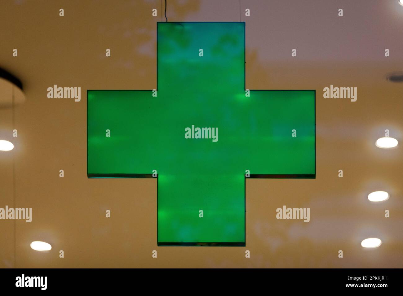 Green pharmacy cross sign displayed in the window of a pharmacy in ...