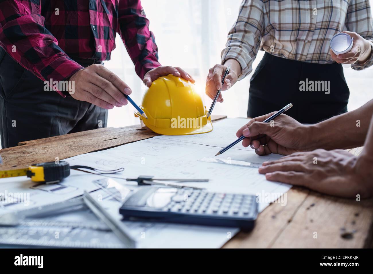 Architect and Engineer working with blueprints for architectural plan ...