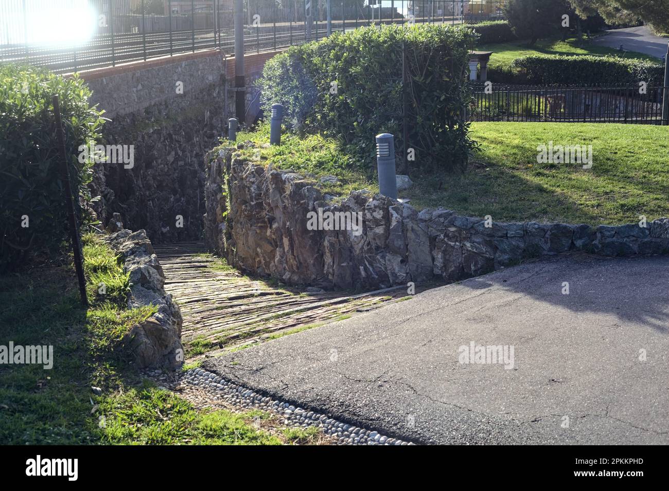 Stone staircase that goes in a covered passageway in a park at sunset ...