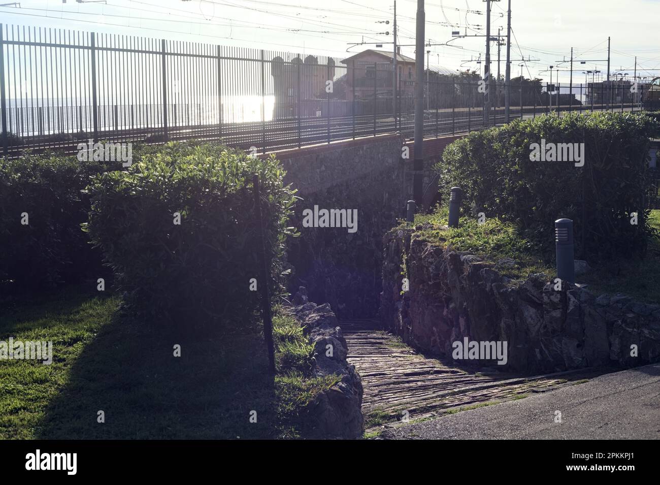 Stone staircase that goes in a covered passageway in a park at sunset ...