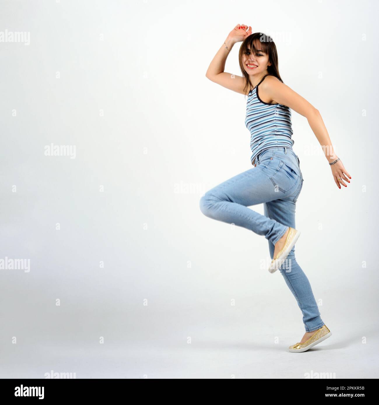 young beautiful dancer posing on studio background in red t-shirt and ...