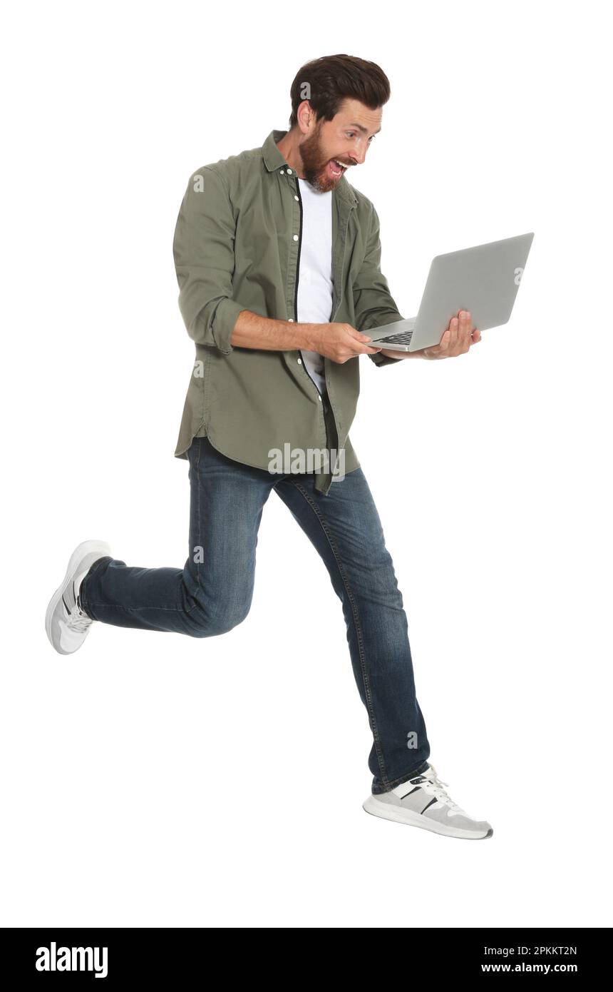 Handsome man with laptop running on white background Stock Photo - Alamy