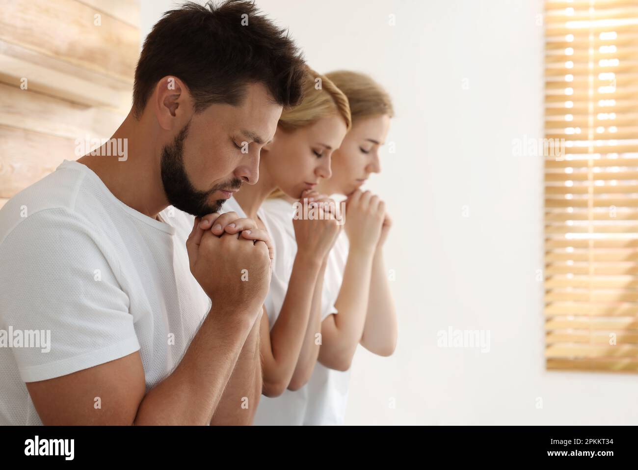 Group of religious people praying together indoors. Space for text ...