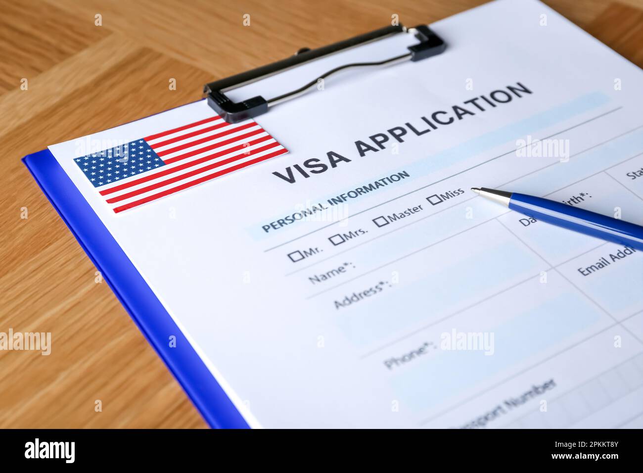 Visa application form for immigration to American flag and pen on table ...