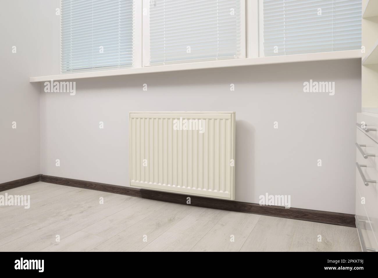 Modern radiator in room. Central heating system Stock Photo - Alamy