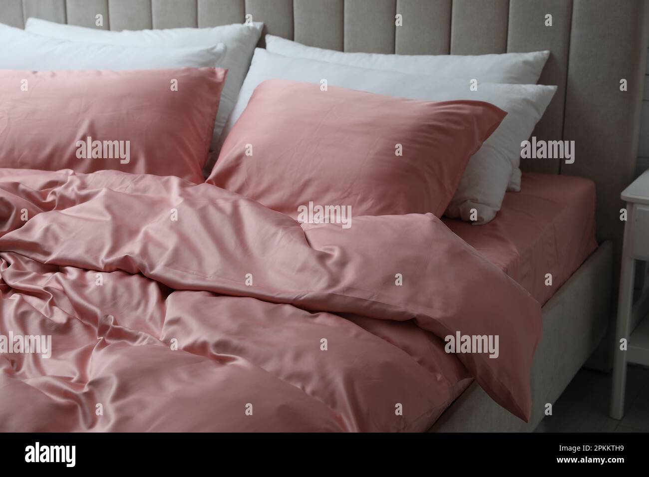 Bed with beautiful pink silk linens indoors Stock Photo - Alamy
