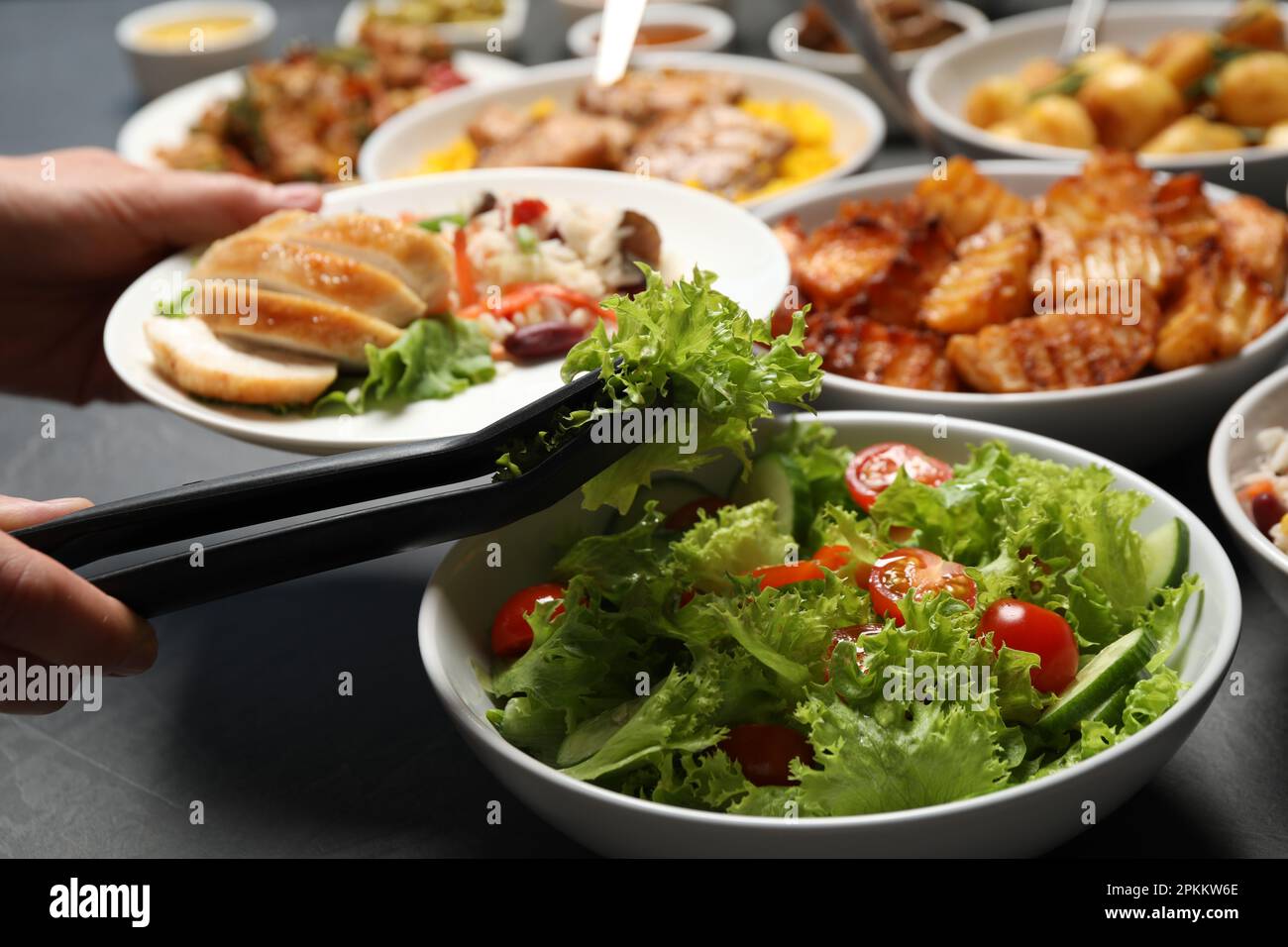 Woman taking food from buffet table, closeup Stock Photo - Alamy