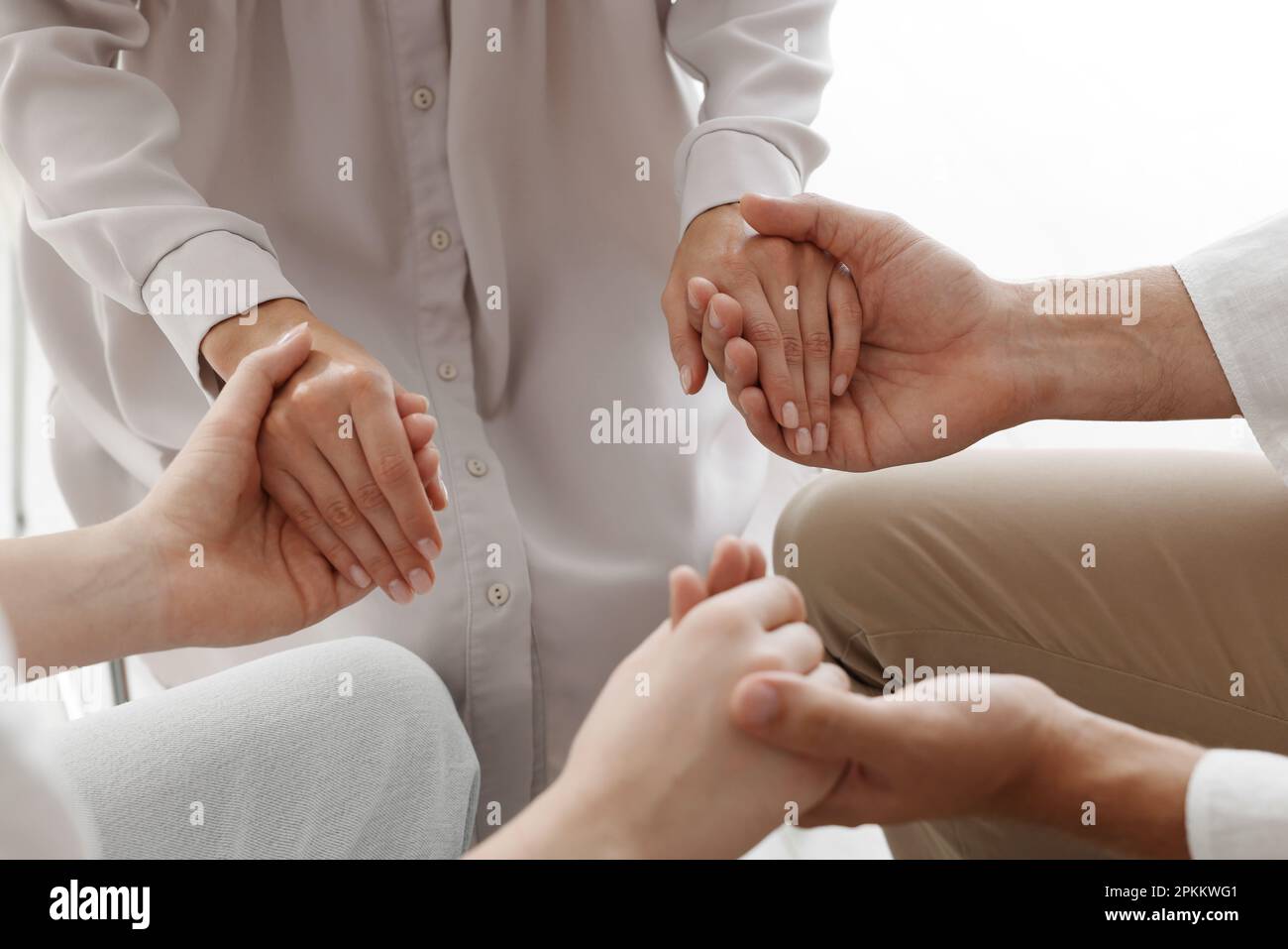 Group of religious people holding hands and praying together indoors ...