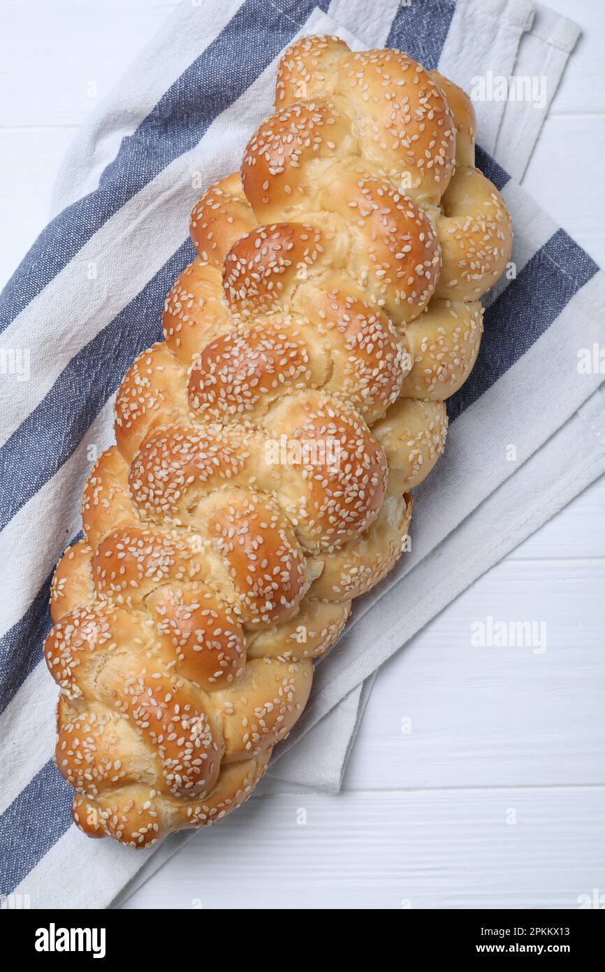Homemade braided bread with sesame seeds on white wooden table, top ...