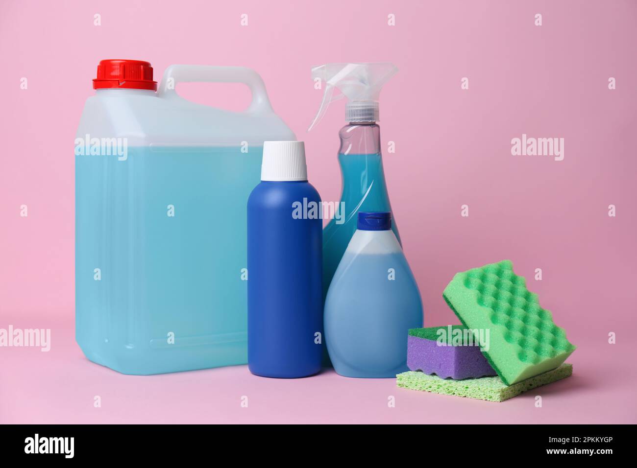 Bottles of different detergents and tools on pink background. Cleaning ...
