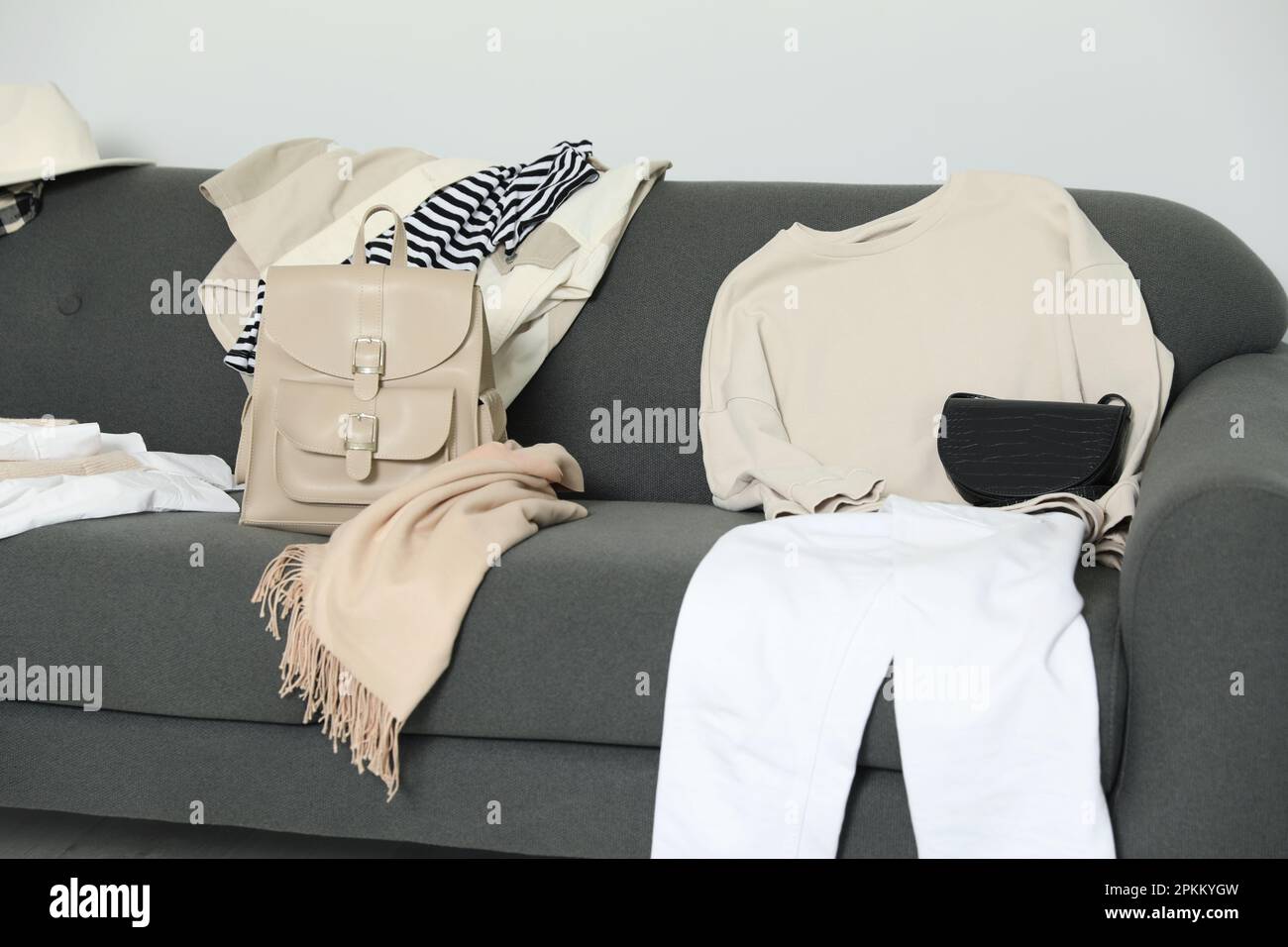 Messy pile of clothes on sofa in living room Stock Photo - Alamy