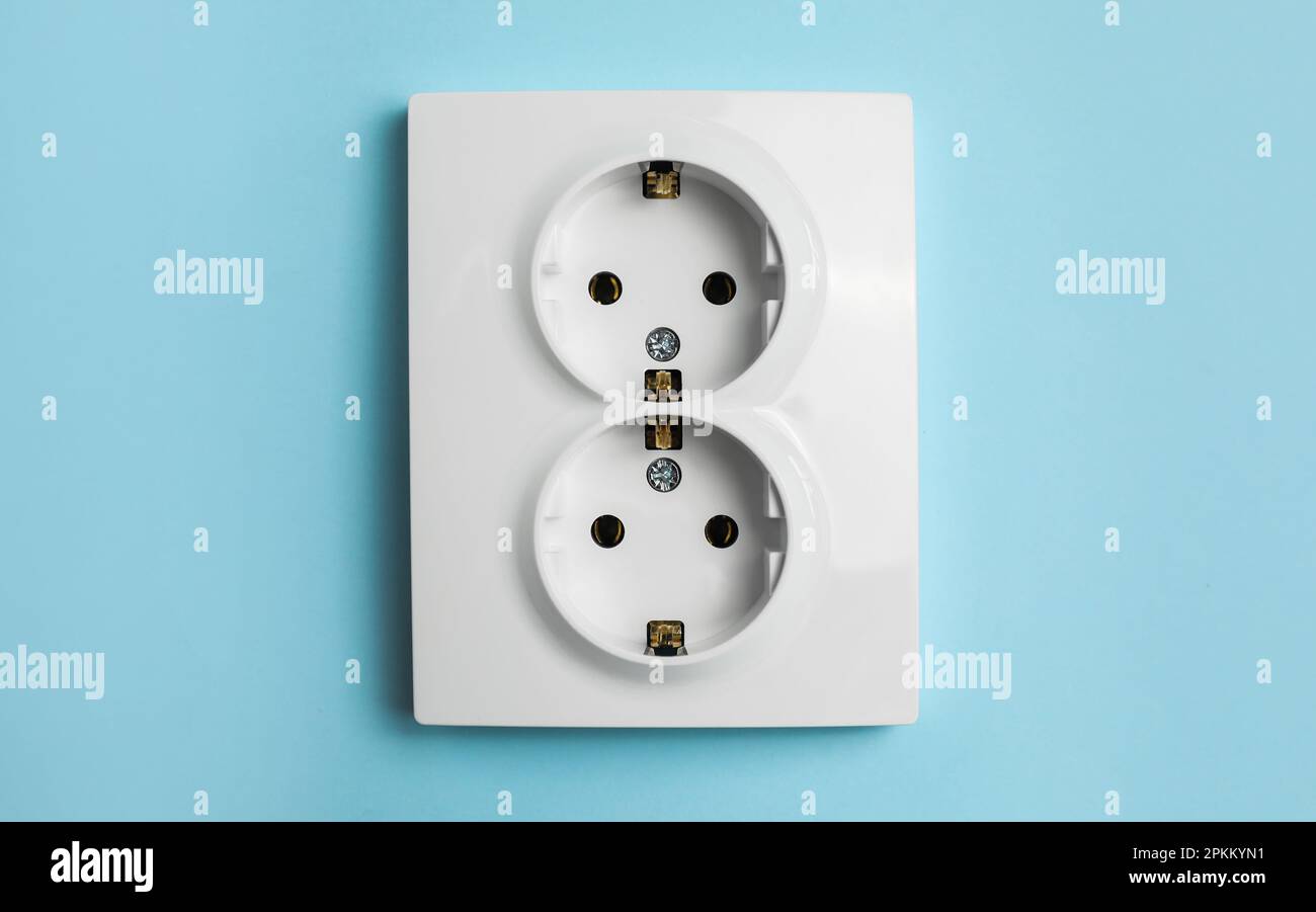 Double power socket on light blue wall. Electrical supply Stock Photo ...