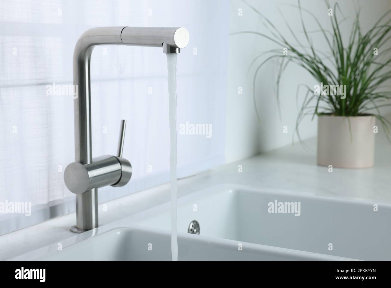 Stream of water flowing from tap in kitchen Stock Photo - Alamy