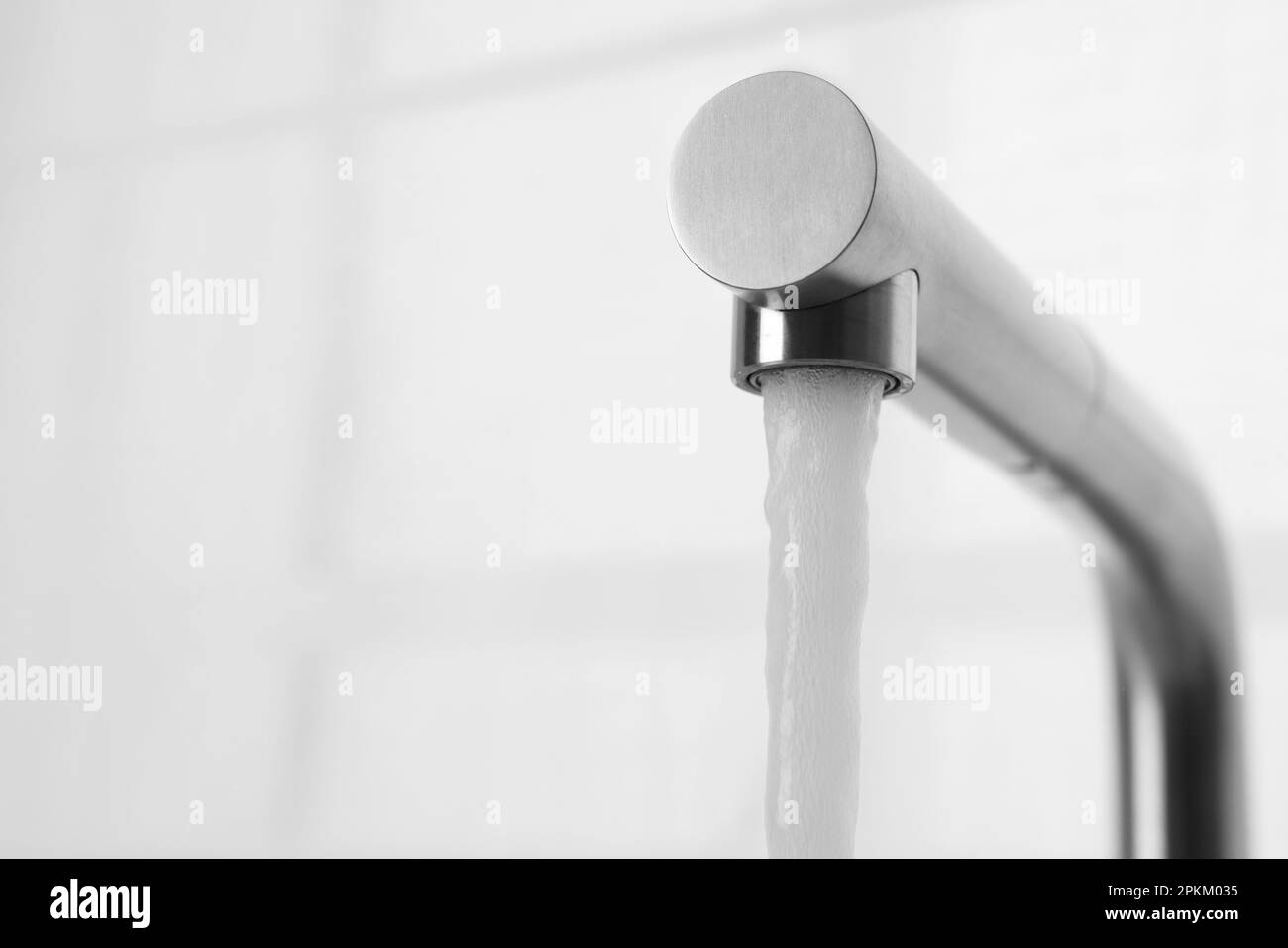 Stream of water flowing from tap on white background, closeup. Space ...