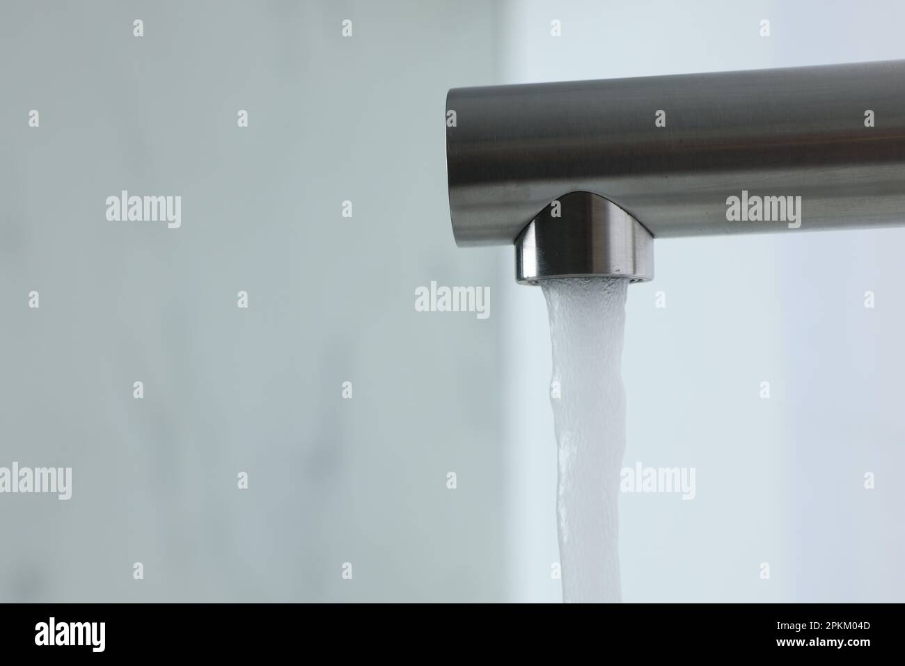 Stream of water flowing from tap on white background, closeup. Space ...