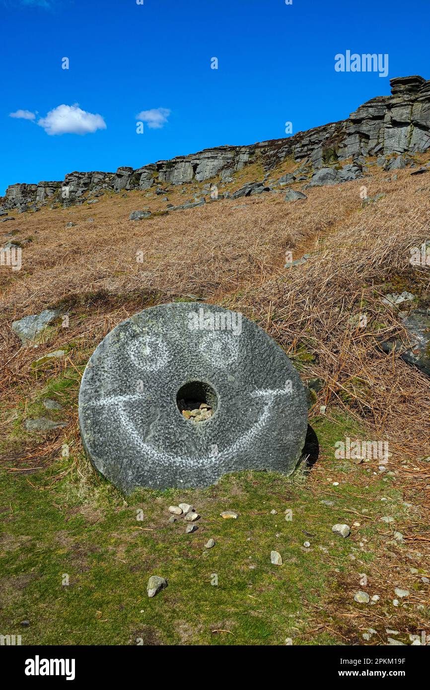 Smiley face scratched on Old abandoned millstones at Stanage Edge, a ...
