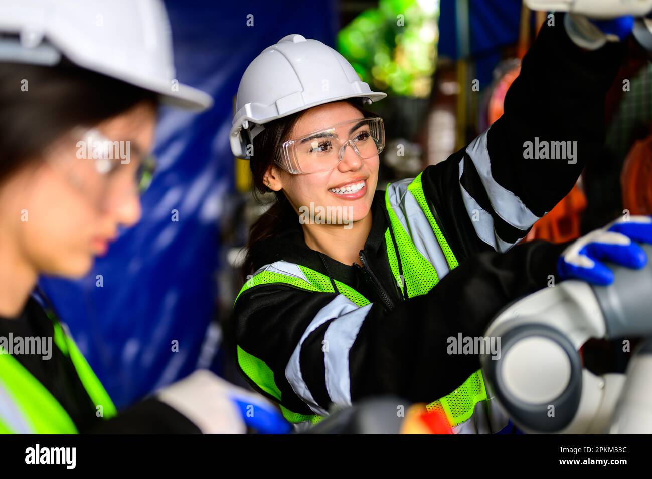 Happy female maintenance workers working at industrial factory Stock ...