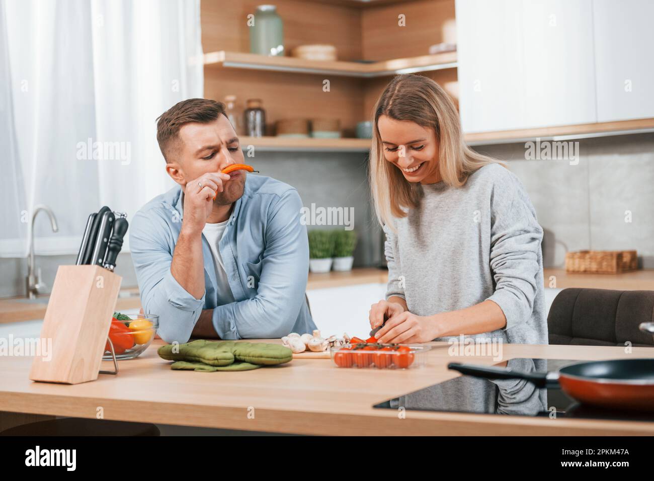 Cute people. Couple preparing food at home on the modern kitchen Stock ...