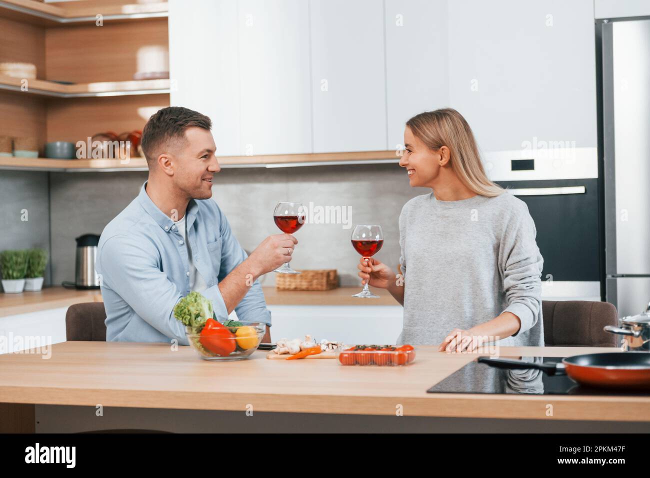 Cute people. Couple preparing food at home on the modern kitchen Stock ...