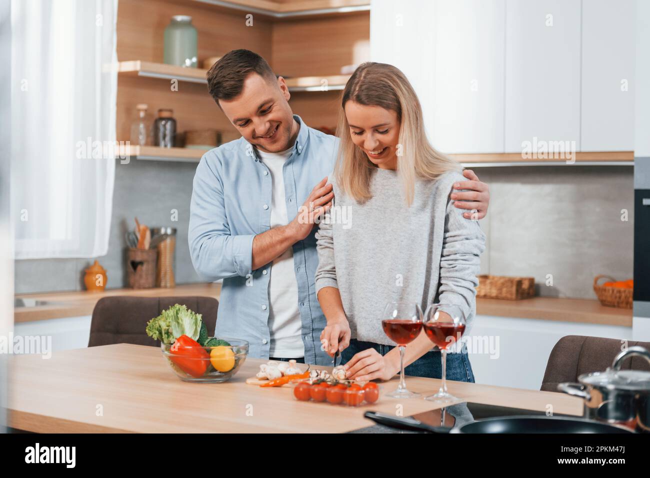 Cute people. Couple preparing food at home on the modern kitchen Stock ...