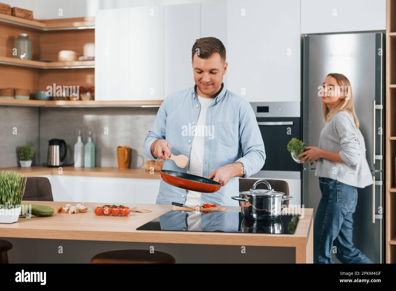 Preparing dinner. Couple at home on the modern kitchen Stock Photo - Alamy
