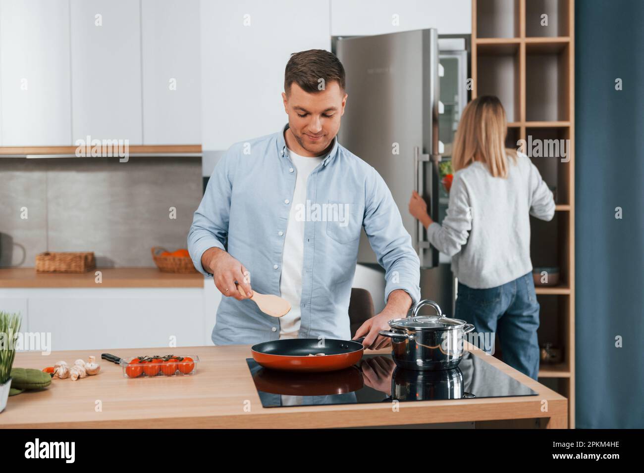 Preparing dinner. Couple at home on the modern kitchen Stock Photo - Alamy